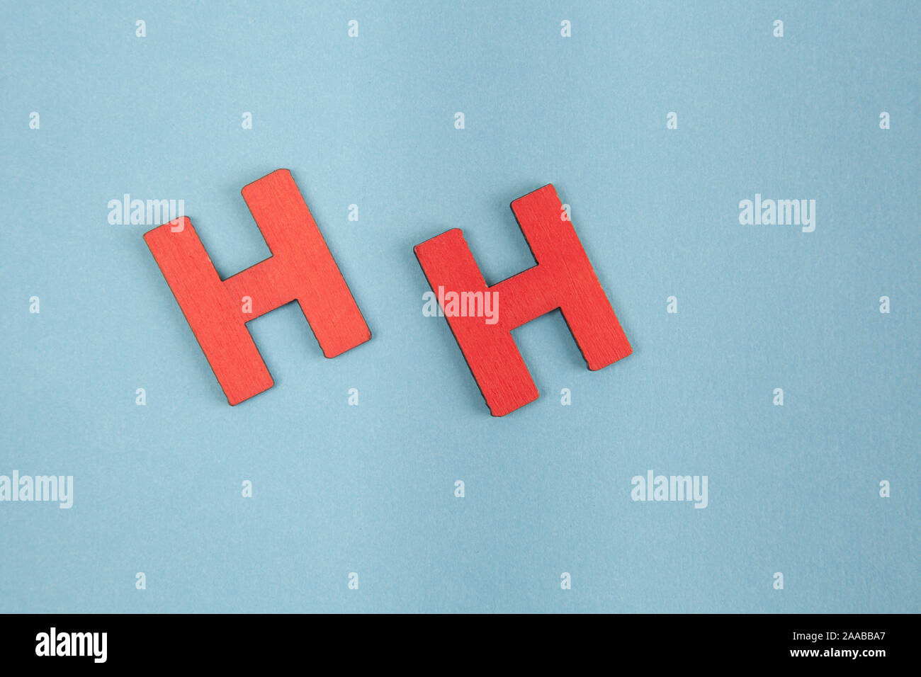 Capital letters H in red color arranged on blue background with copy ...