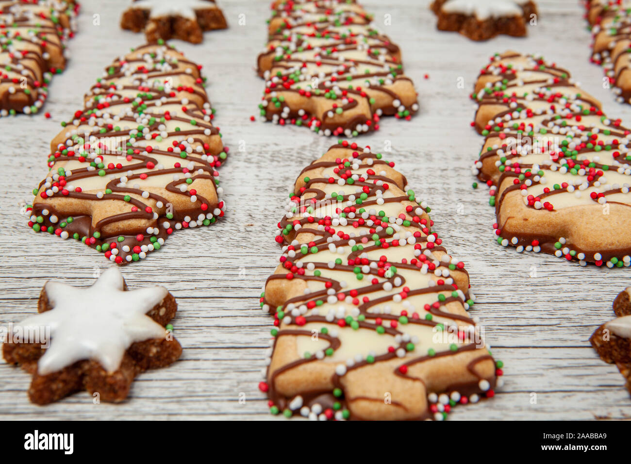 Christmas tree biscuits on white wood in perspective with shallow focus ...