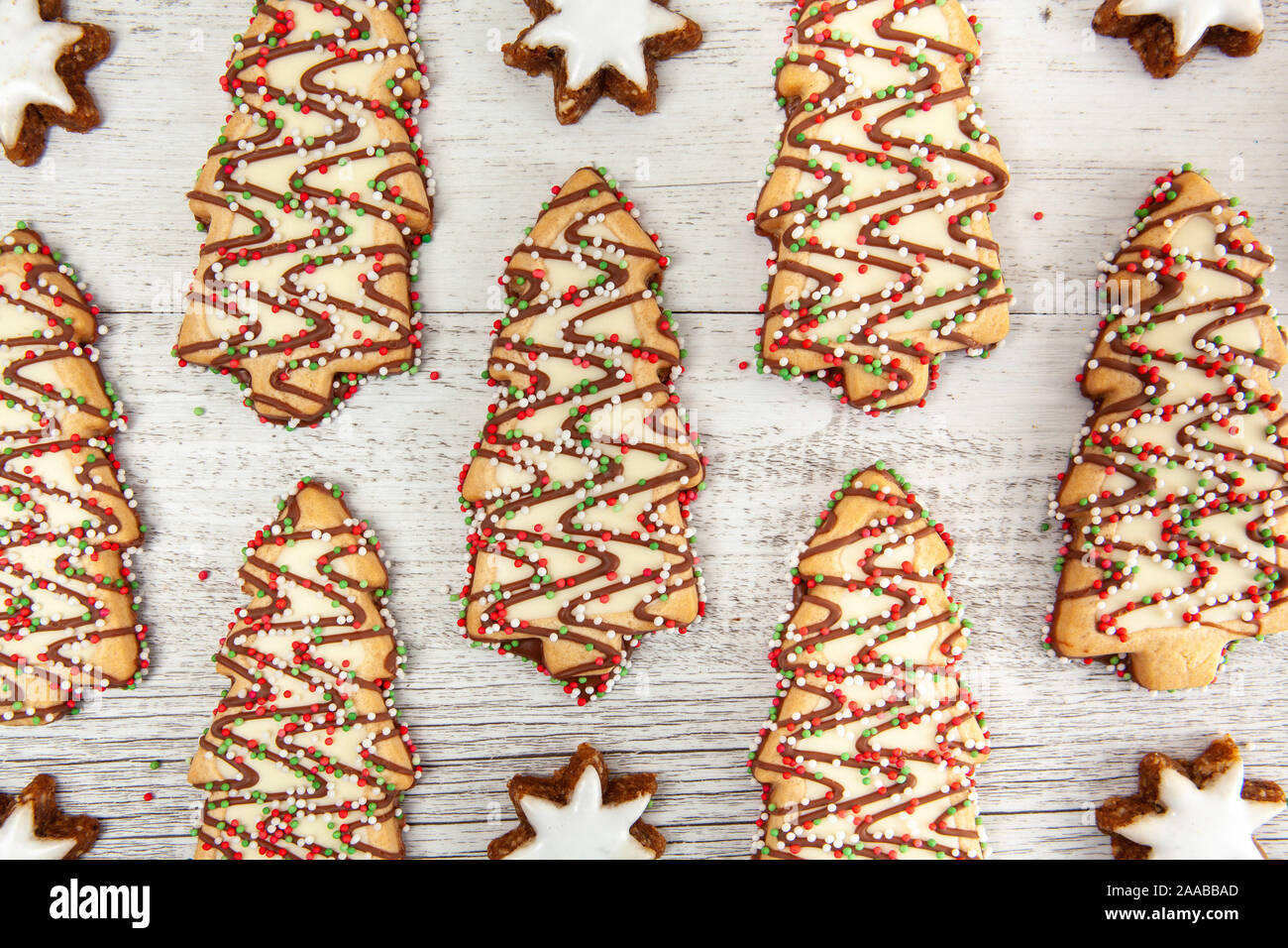 Christmas tree biscuits with almond stars pattern on white rustic wood ...