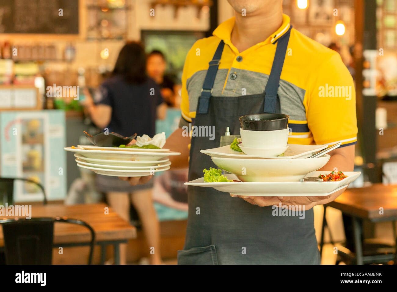 Waiter removing dirty dishes from the tables in restaurant Stock Photo ...