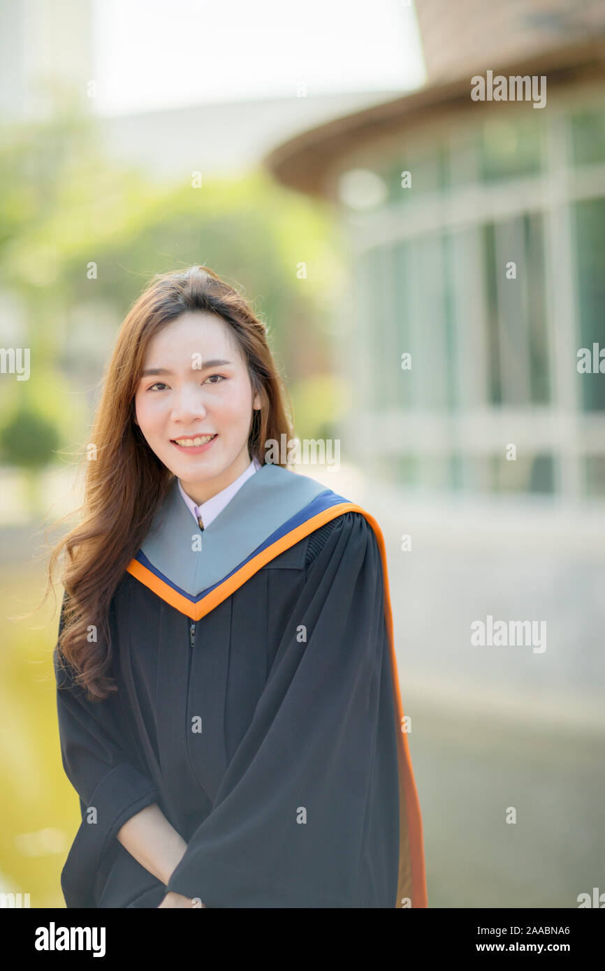 toothy smiling face of beautiful asian younger woman wearing university ...