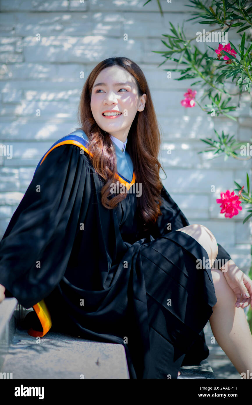 toothy smiling face of beautiful asian younger woman wearing university ...