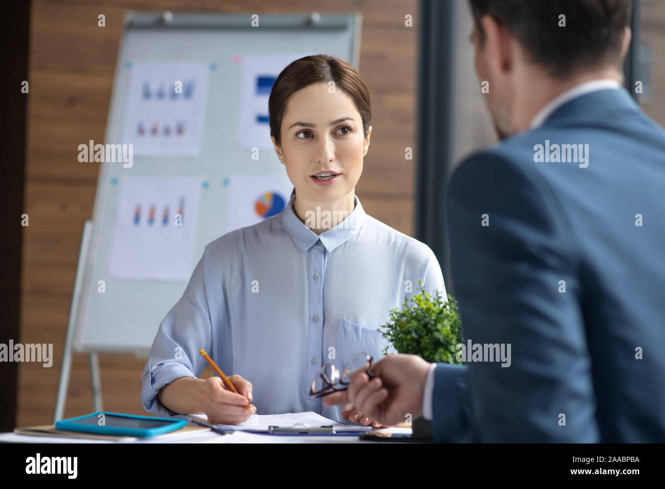 Secretary making notes while listening to her boss giving her tasks for ...