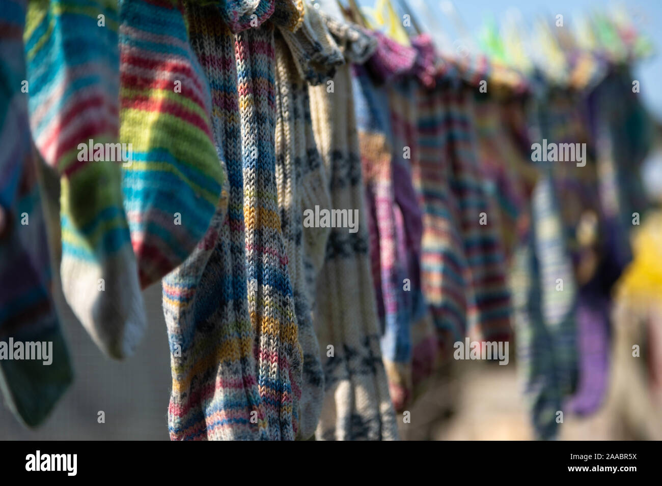 Colorful woolen socks drying, pegged on the washing line Stock Photo ...