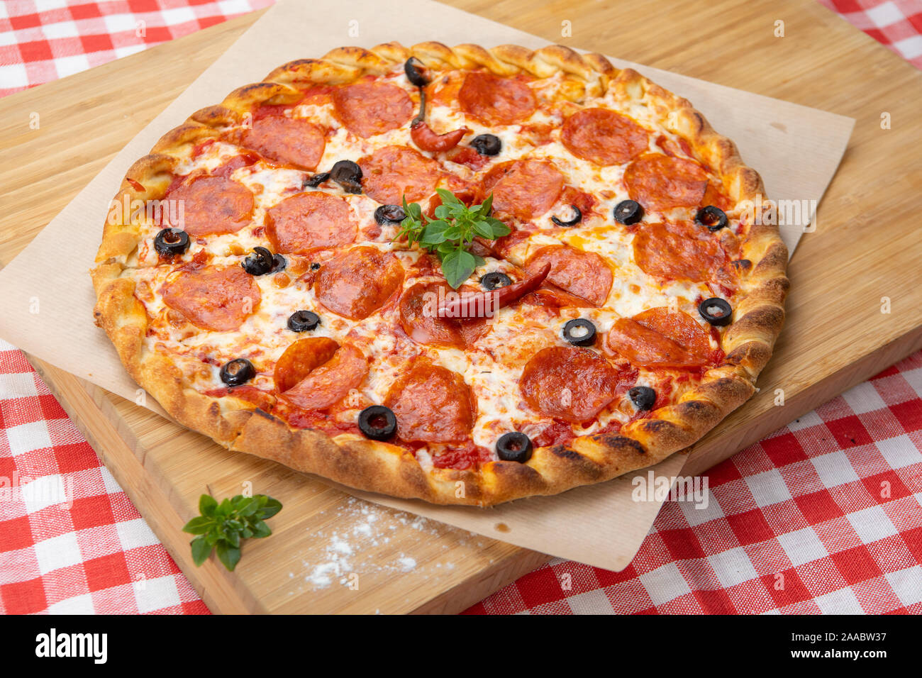 Pepperoni pizza close-up with various ingredients decorated with Basil ...