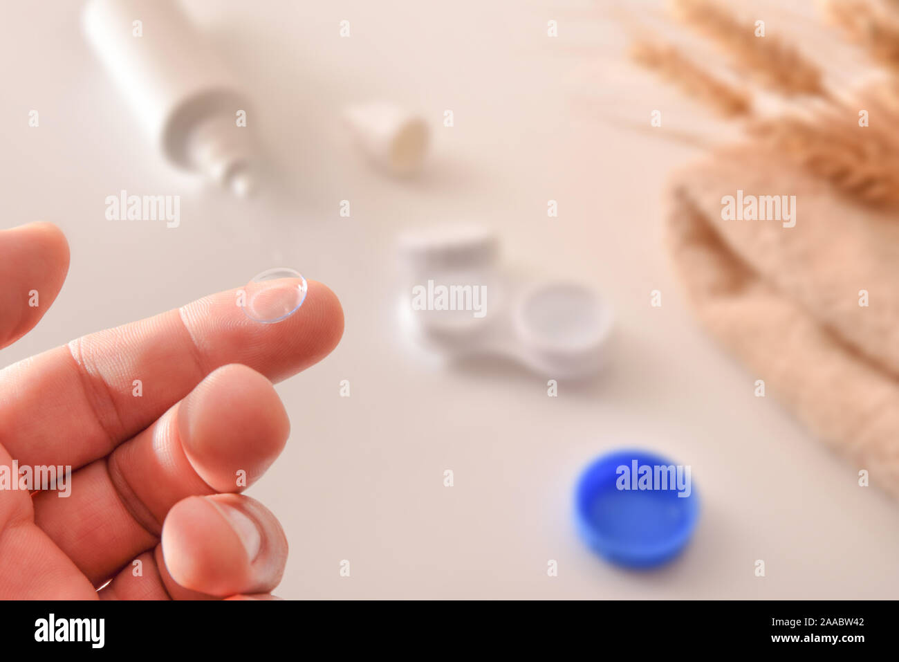 Hand with lens on the finger with background maintenance products ...