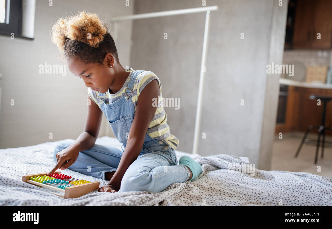 Happy african american kid girl learn to count at home with abacus ...