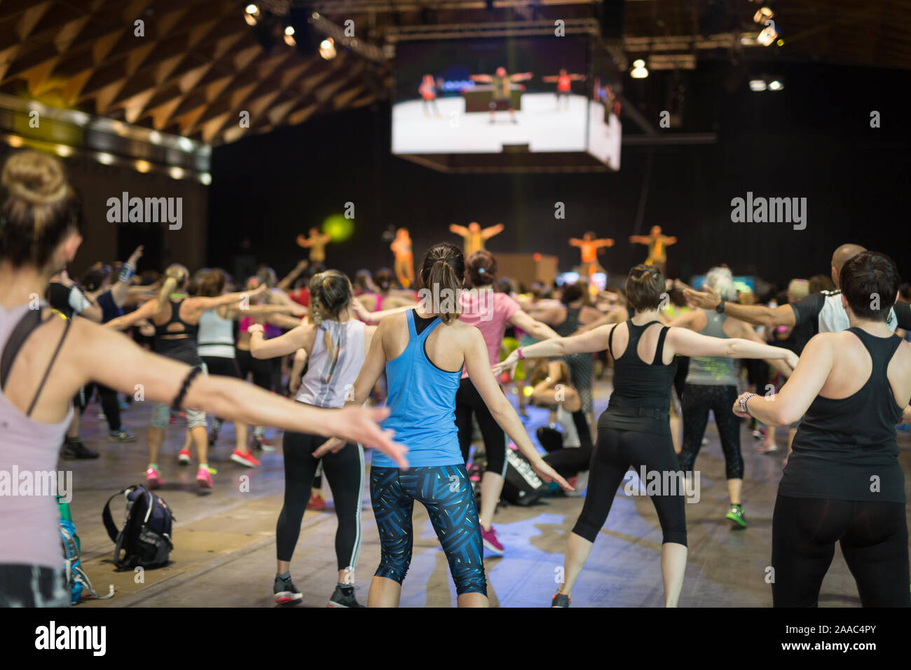 Fitness Workout in Gym: People doing Exercises in Class with Music and ...