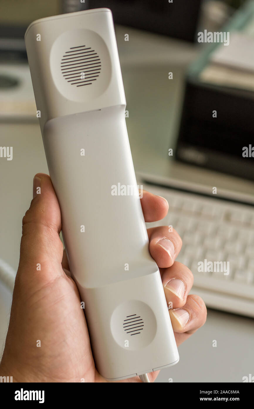 Telephone receiver in the office with computer keyboard in the ...