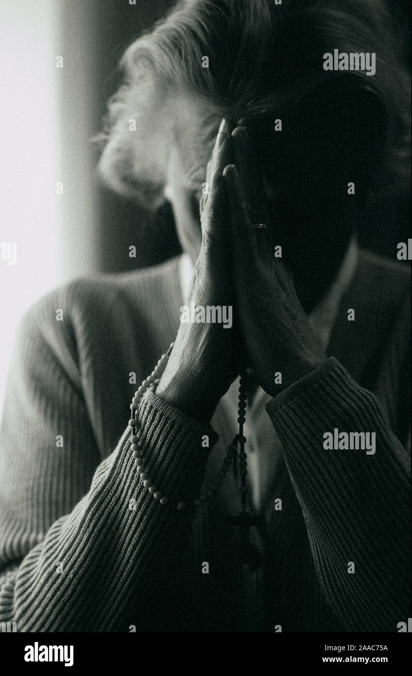 old woman praying with her hands joined Stock Photo - Alamy