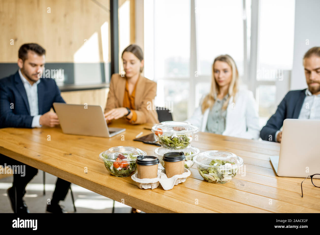 Office workers sitting in the office with business lunches on the ...