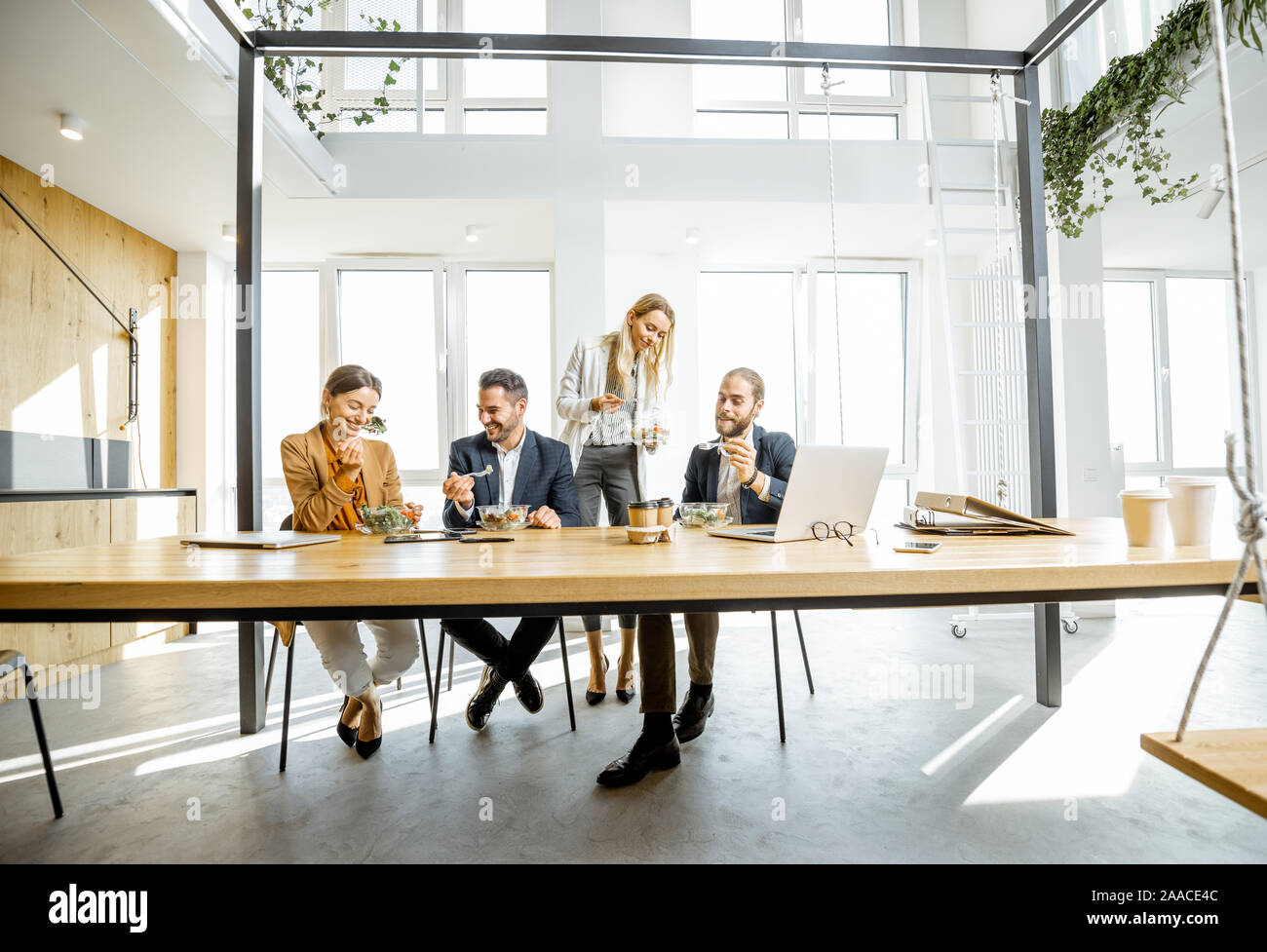 Group of a young office workers eating salads and drinking coffee at ...
