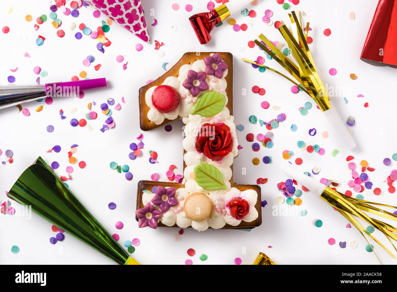 Number one cake decorated with flowers, macarons and confetti isolated ...
