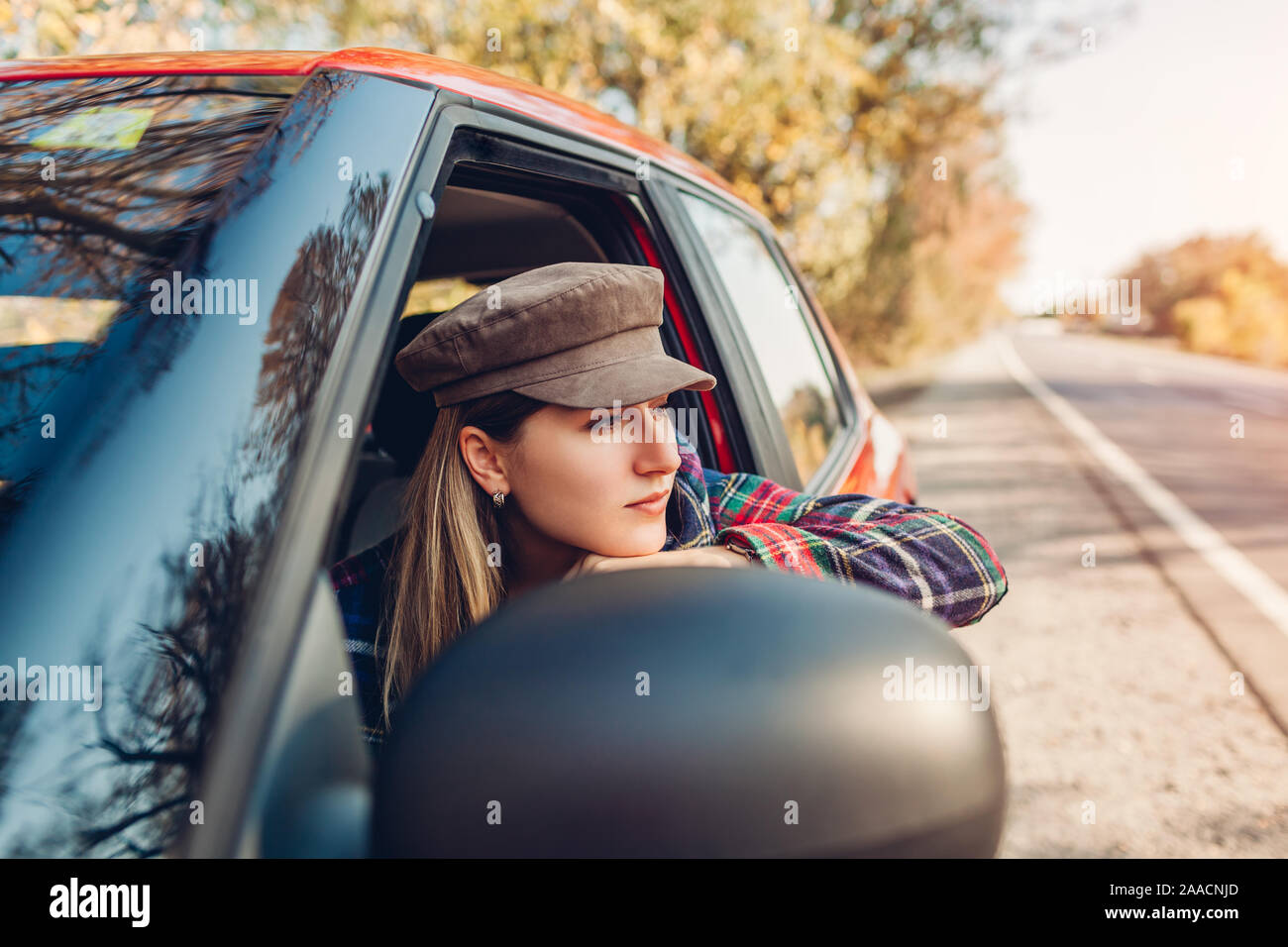Woman relaxing in car. Driver looking out of autimobile window on ...