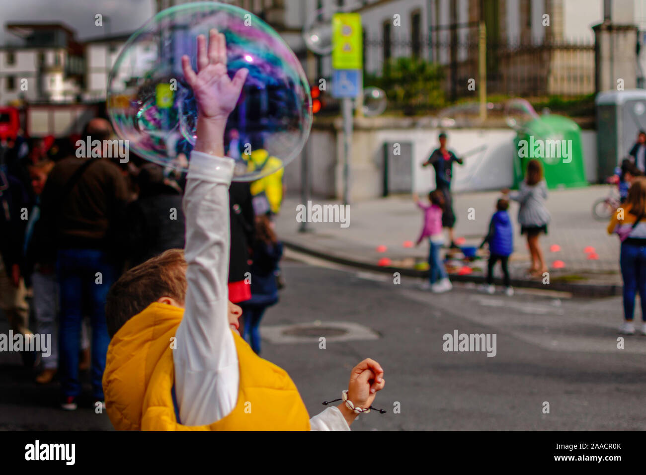 Child about to explode a giant soap bubble, at the festivities Stock ...