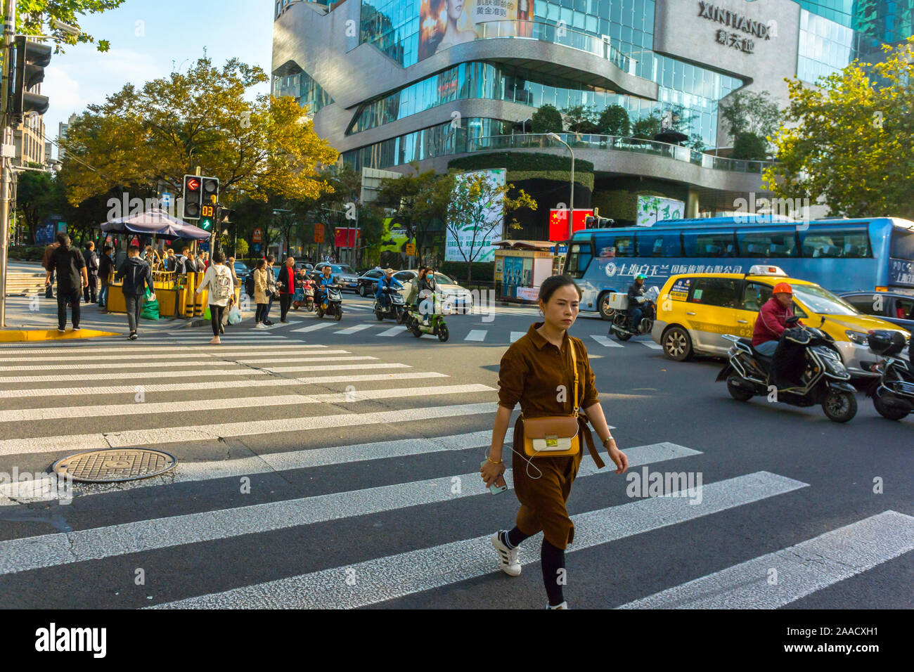 Shanghai, CHina, Young Woman Crossing Street near Luxury Shop Fronts ...