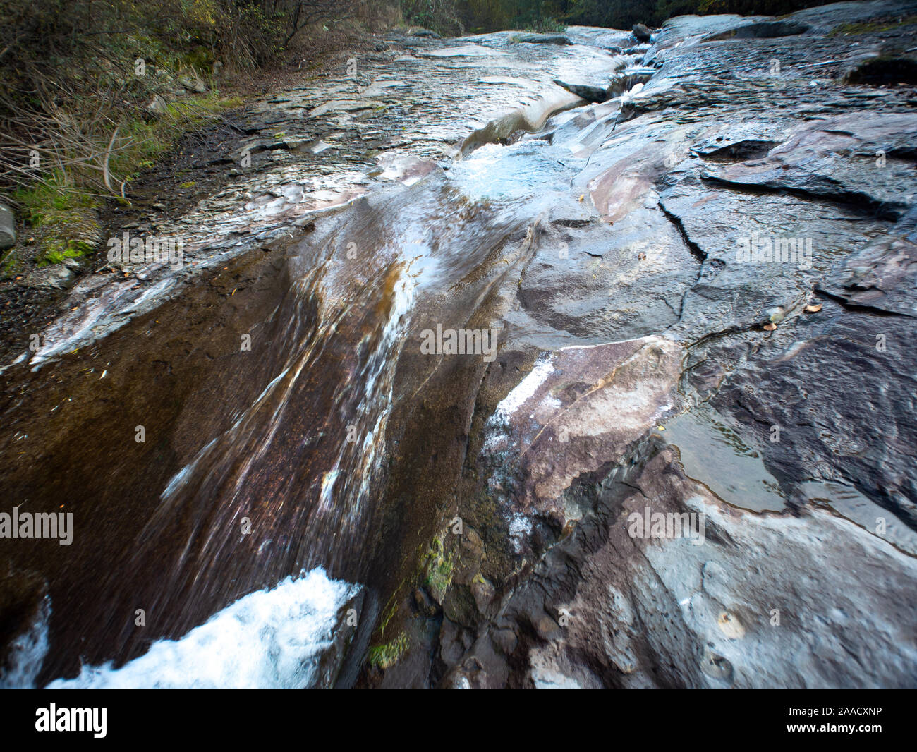Clear water flows into a stone trough of a lanine stream. Closeup Stock ...