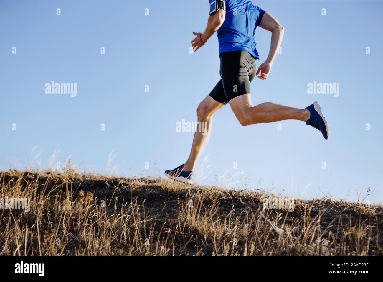 running uphill male runner background in blue sky Stock Photo - Alamy