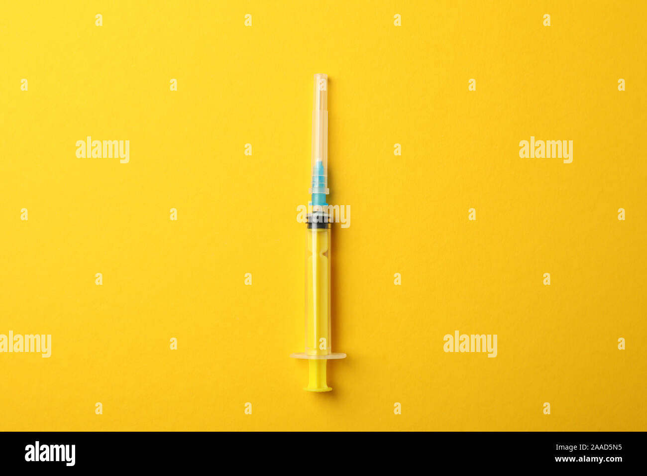 Syringe on yellow background, space for text Stock Photo - Alamy