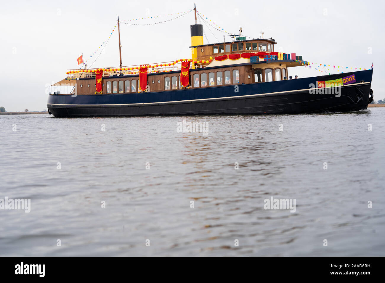 Traditional steamboat sailing on the water with festive clothing and ...