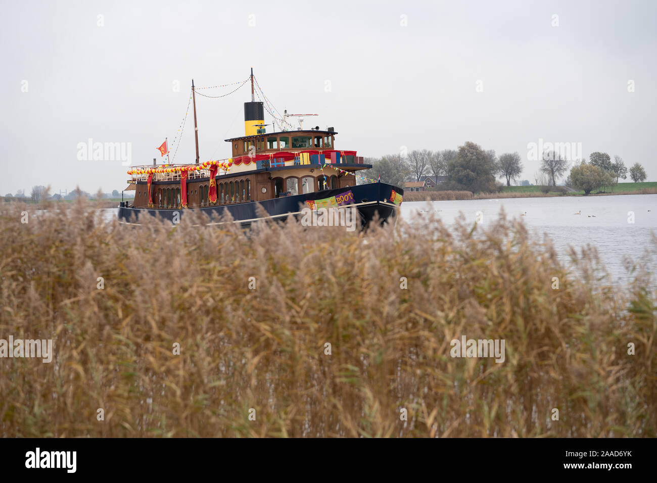 Traditional steamboat sailing on the water with festive clothing and ...