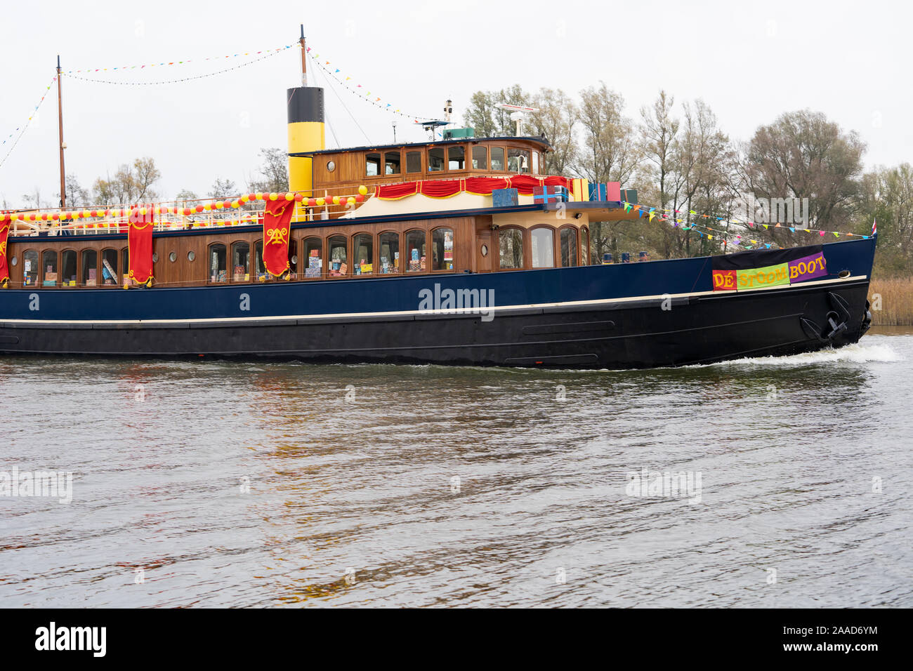 Traditional steamboat sailing on the water with festive clothing and ...
