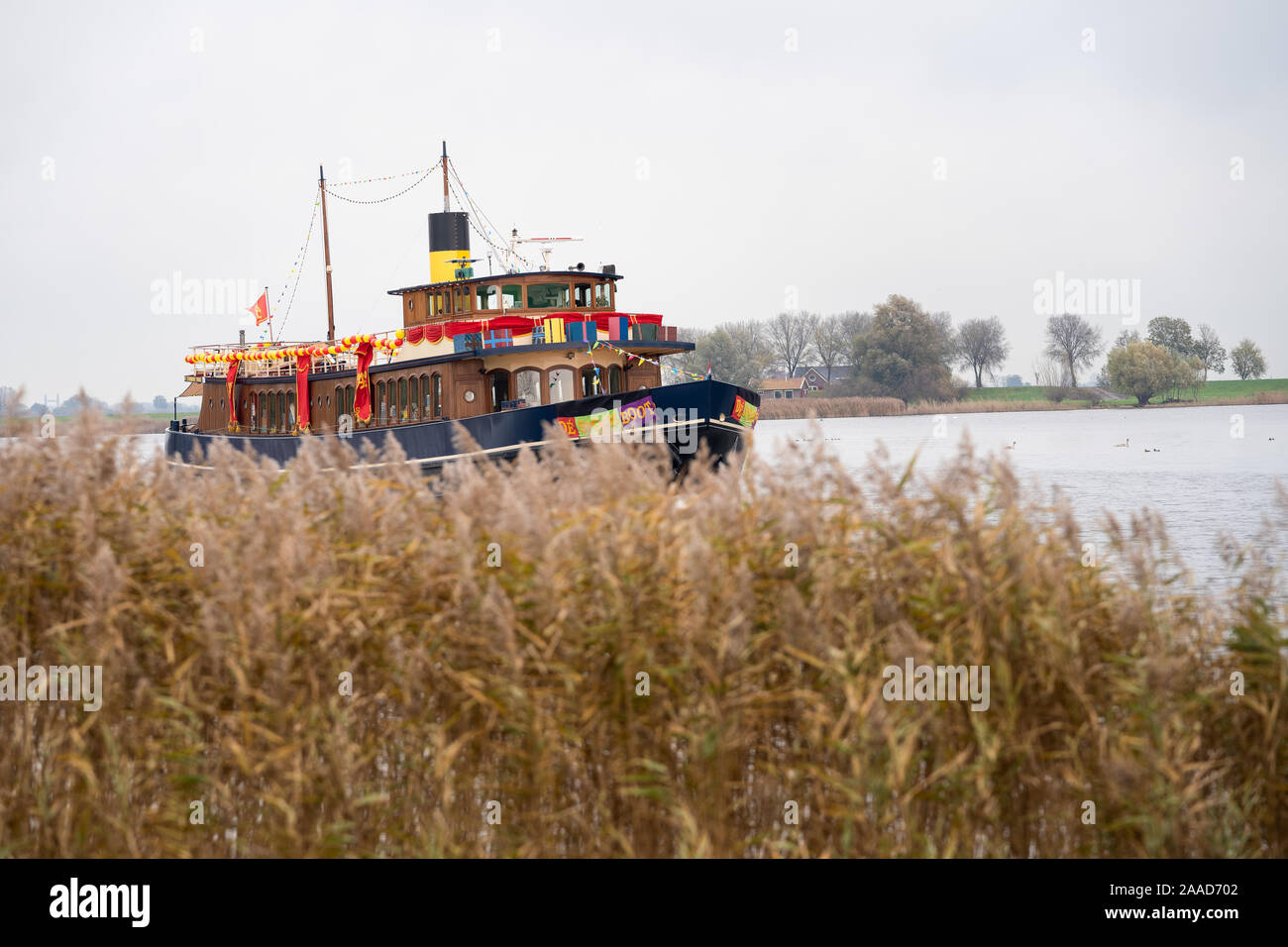 Traditional steamboat sailing on the water with festive clothing and ...
