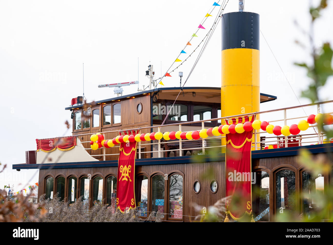 Traditional steamboat sailing on the water with festive clothing and ...
