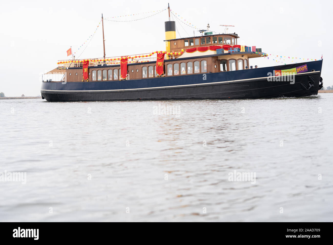 Traditional steamboat sailing on the water with festive clothing and ...