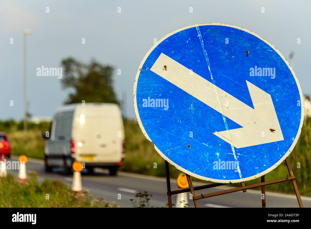 roadworks directional arrow sign on UK motorway at evening with traffic ...