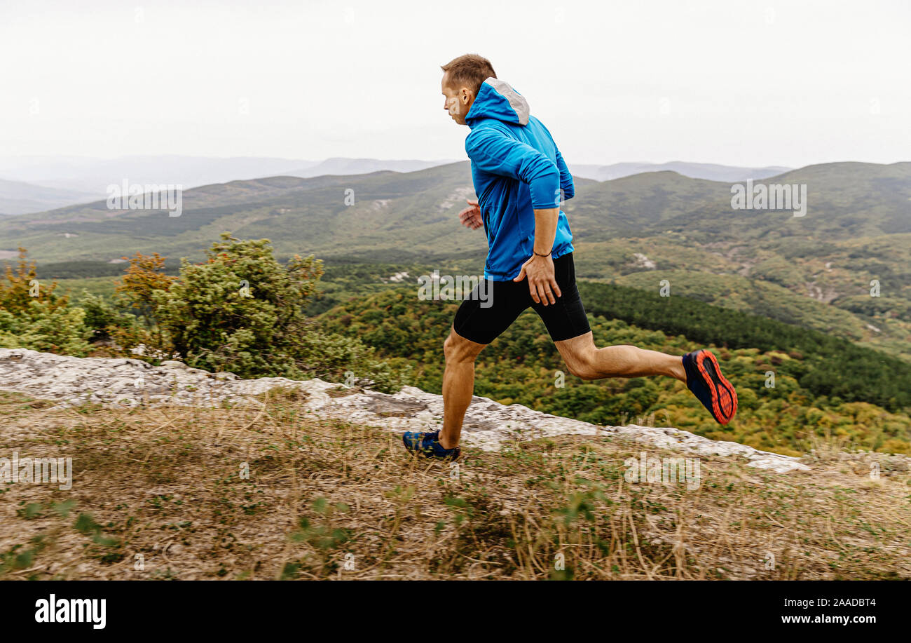 mountain trail male runner run on edge of cliff Stock Photo - Alamy
