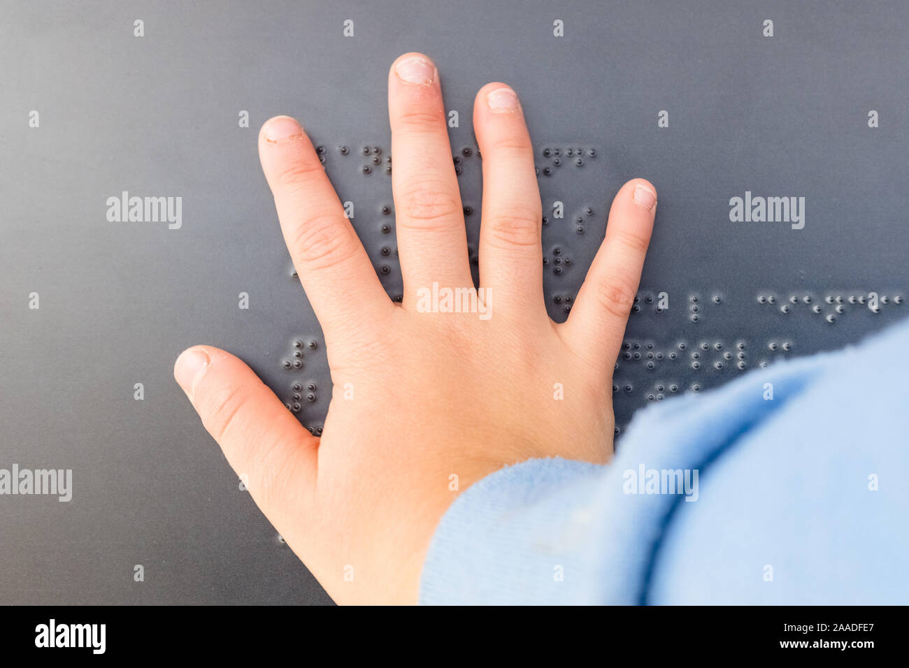 A blind child's hand on a text written in Braille Stock Photo - Alamy