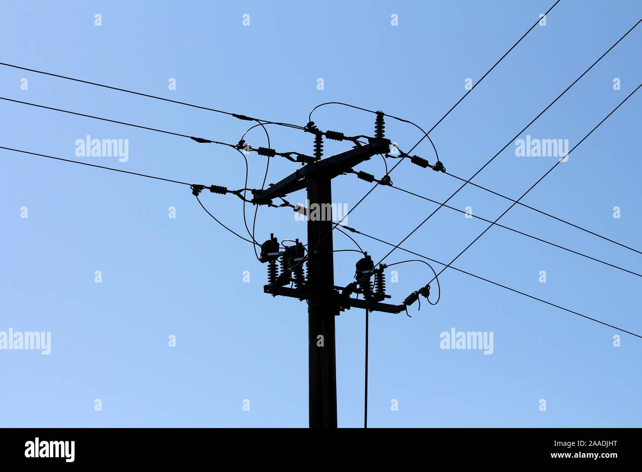 Dark silhouette of concrete electrical utility pole with multiple ...