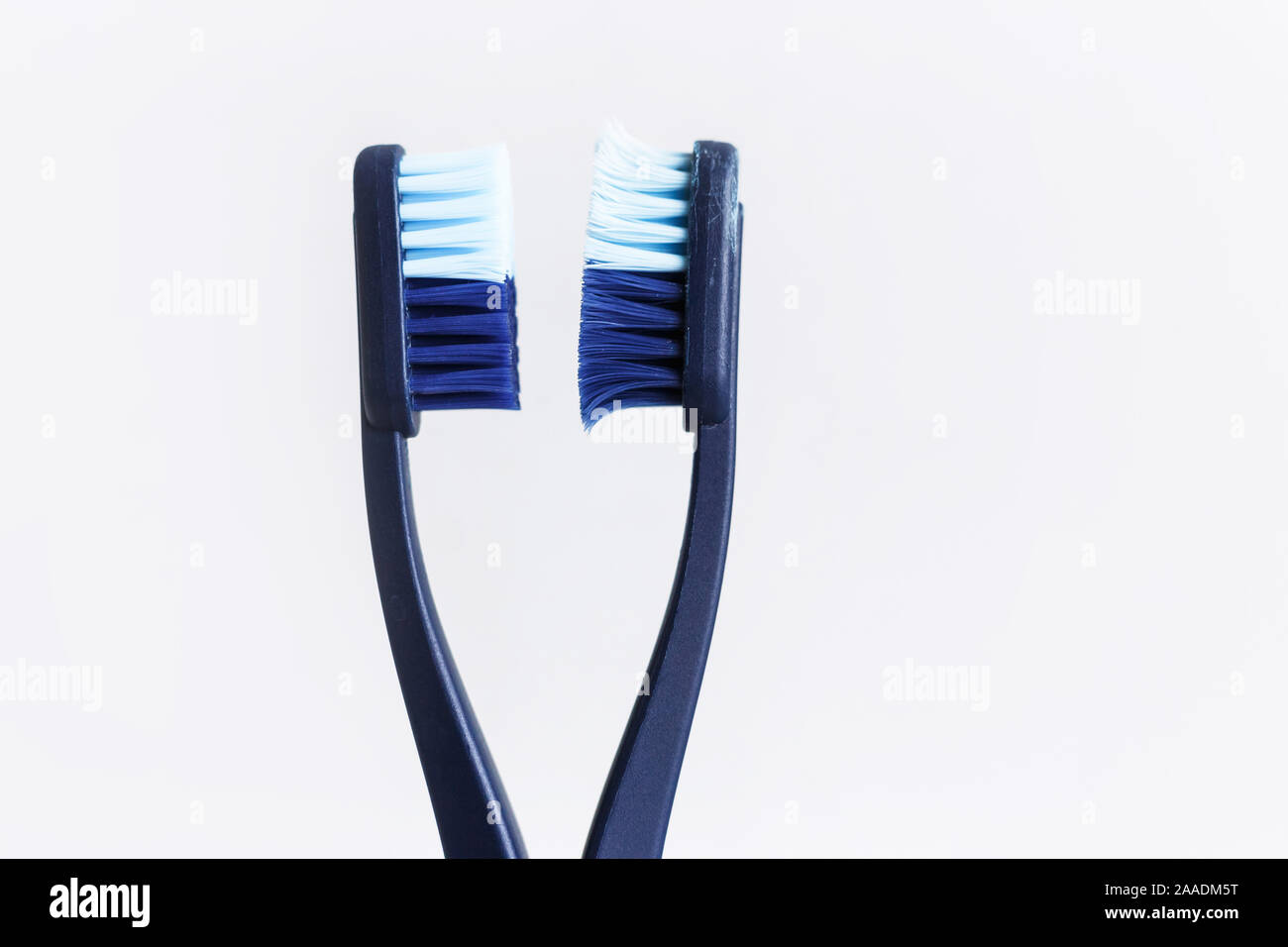 New and used blue color toothbrush in cup on white Stock Photo - Alamy
