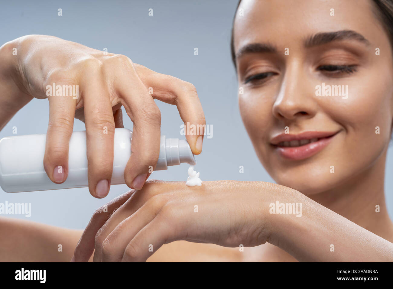 Positive delighted young female pouring down cream Stock Photo - Alamy