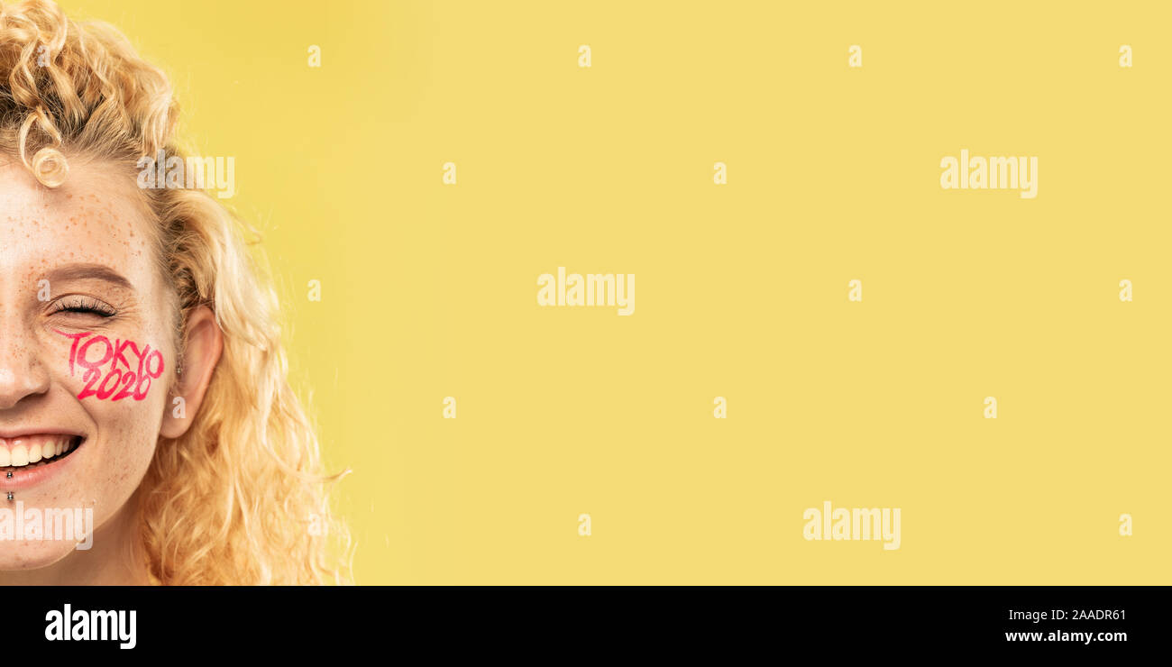 Caucasian young woman's close up portrait on yellow studio background ...