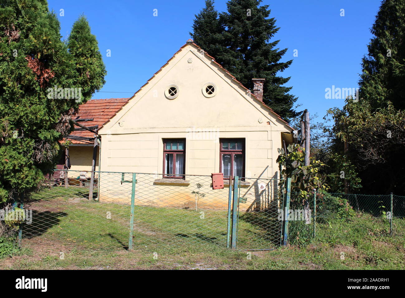 Small old suburban family house with two windows and decorative attic ...