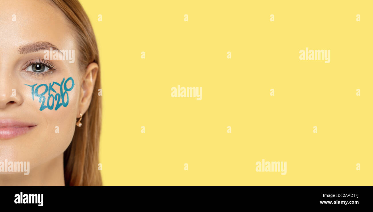 Caucasian young woman's close up portrait on yellow studio background ...