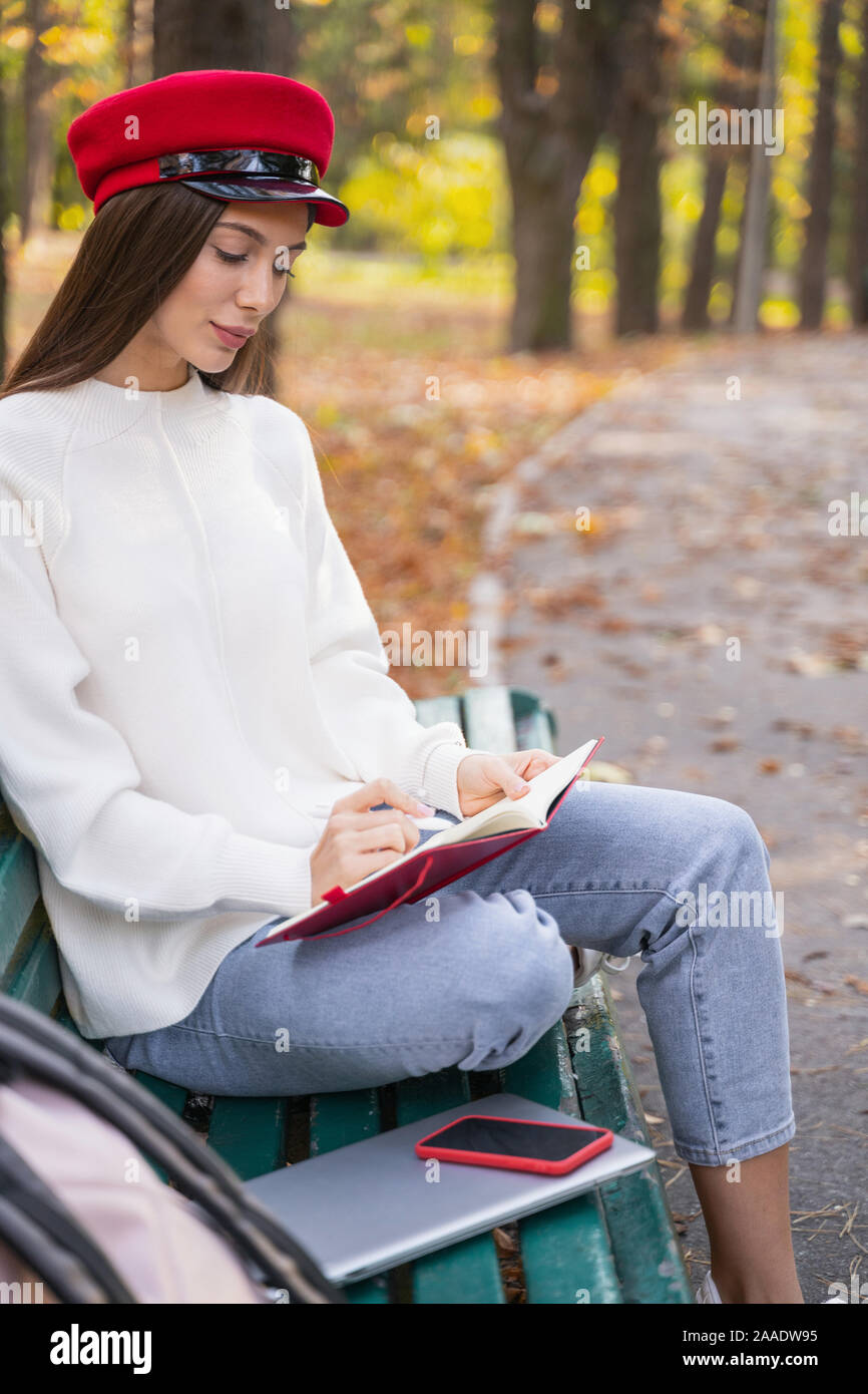 Relaxed young female making notes into her diary Stock Photo - Alamy