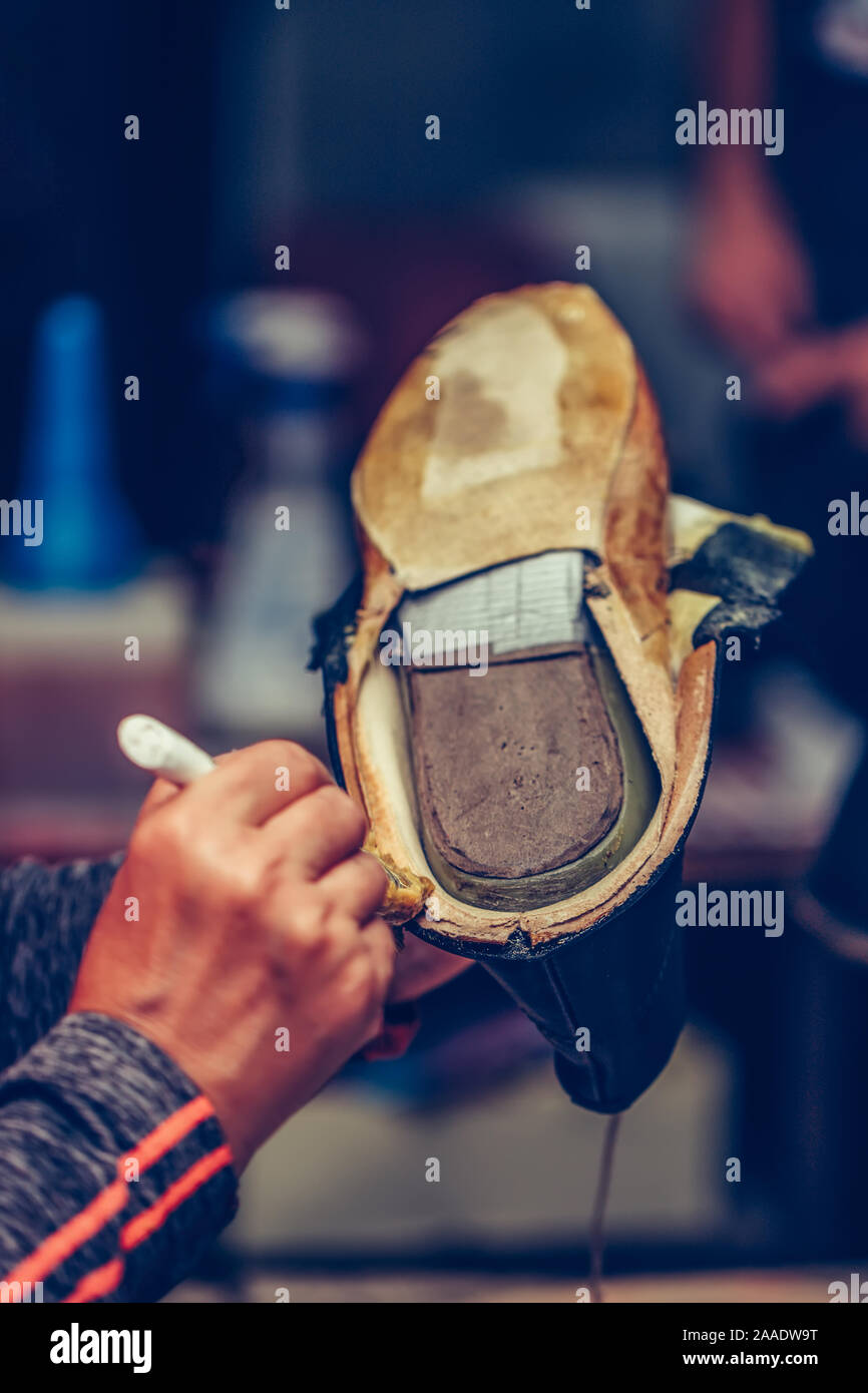 Hands of an experienced worker in the handmade footwear industry ...