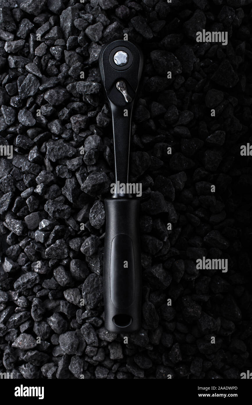 Professional reinforced black matt hex wrench placed on a stony ...