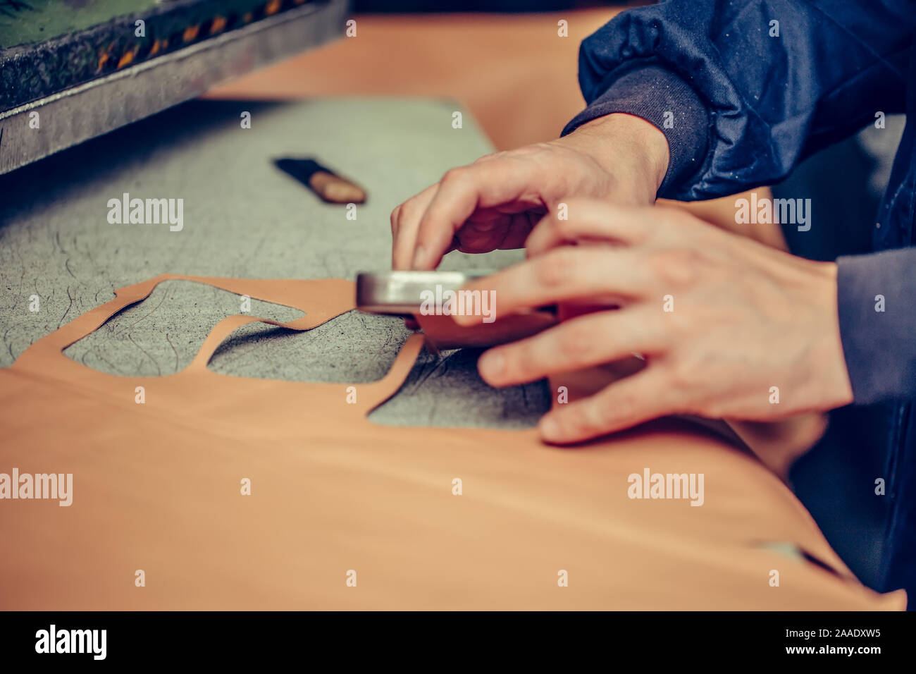 Close up of a shoemaker cutting leather in the handmade footwear ...