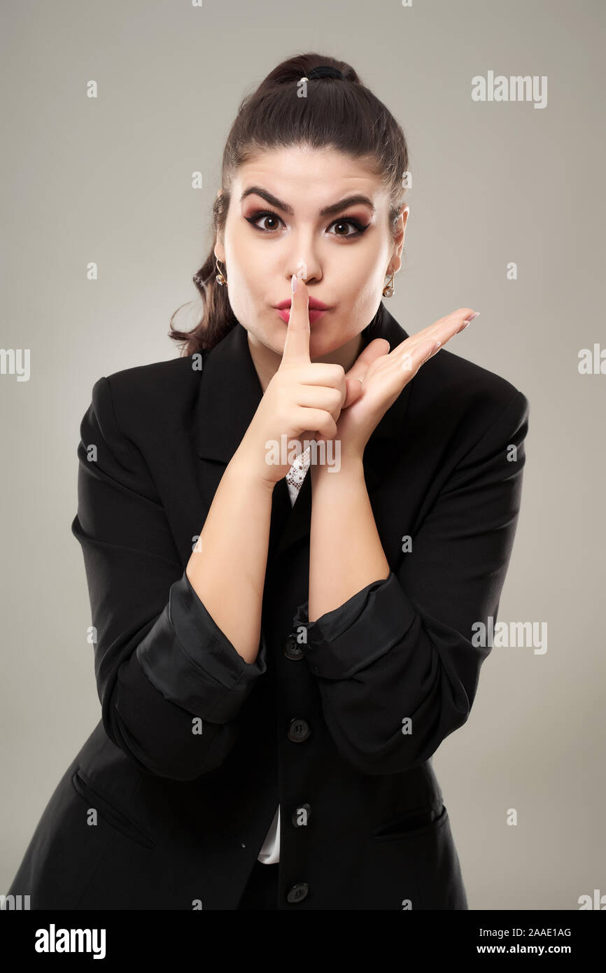 Worried businesswoman making silence sign Stock Photo - Alamy