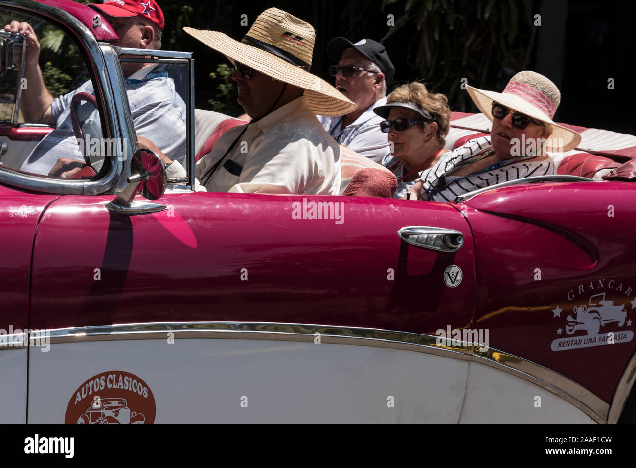 A party of tourists being driven in an American classic car for a tour ...