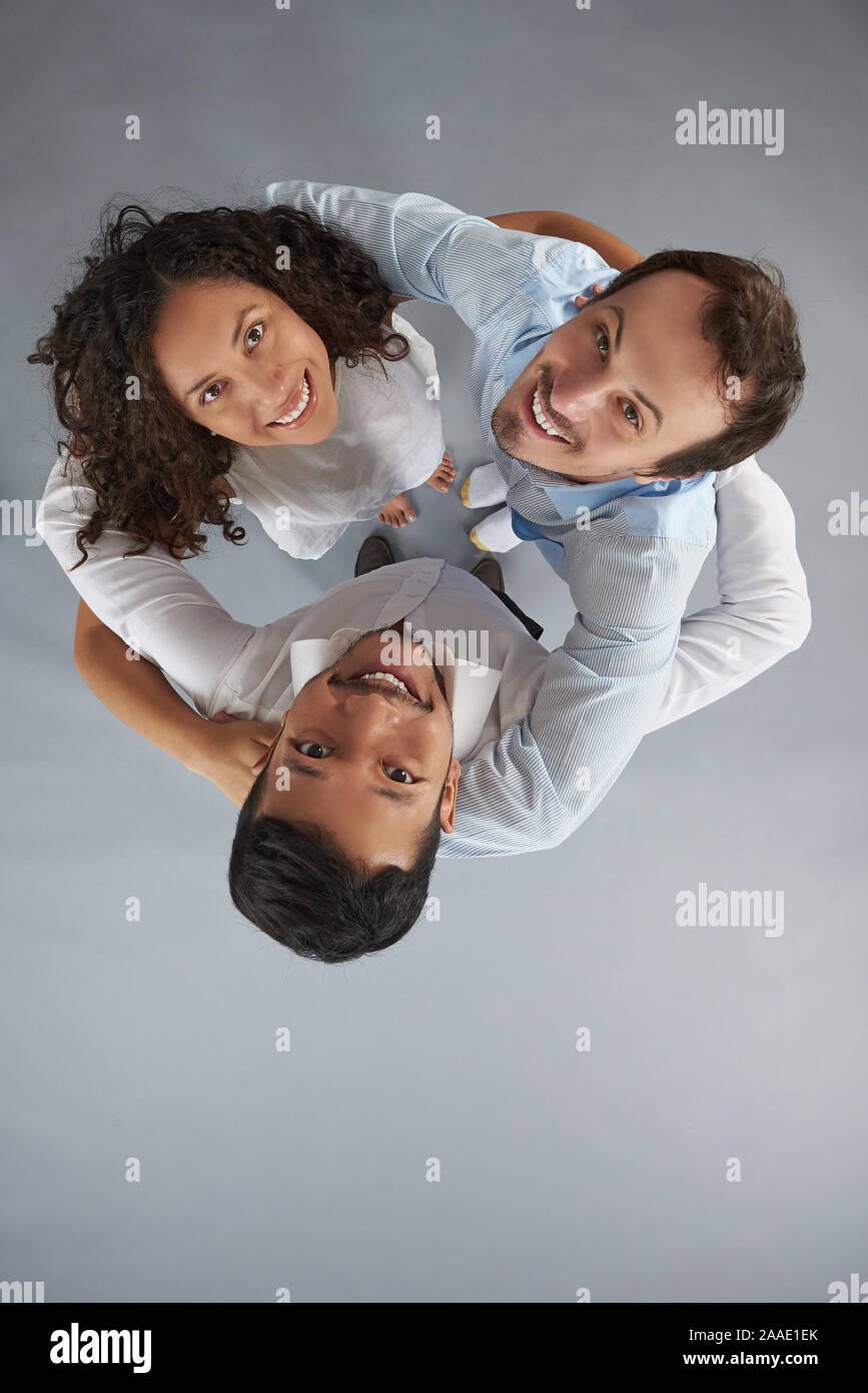 Group of young smiling people looking up above top view in studio ...