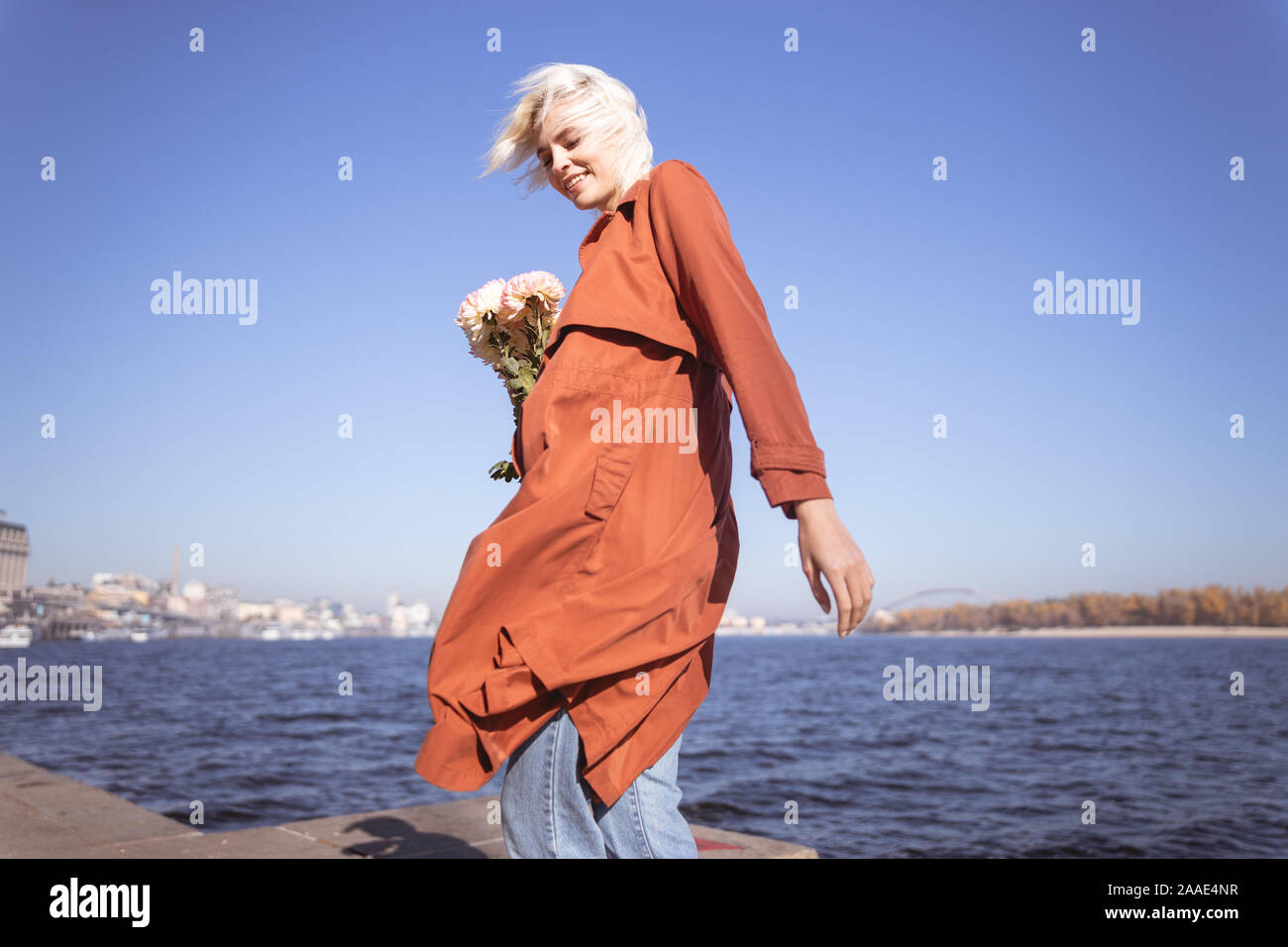 Pretty woman loving the wind near the river Stock Photo - Alamy