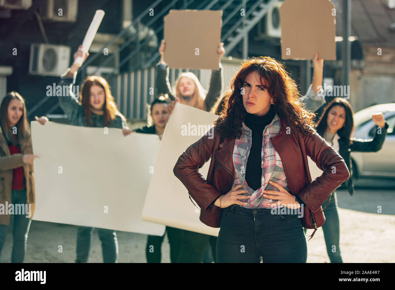 Young woman with angry face in front of people protesting about women's ...