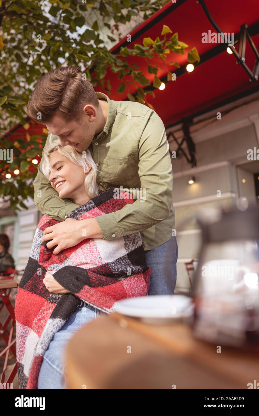 Pretty woman enjoying hugs of her boyfriend Stock Photo - Alamy
