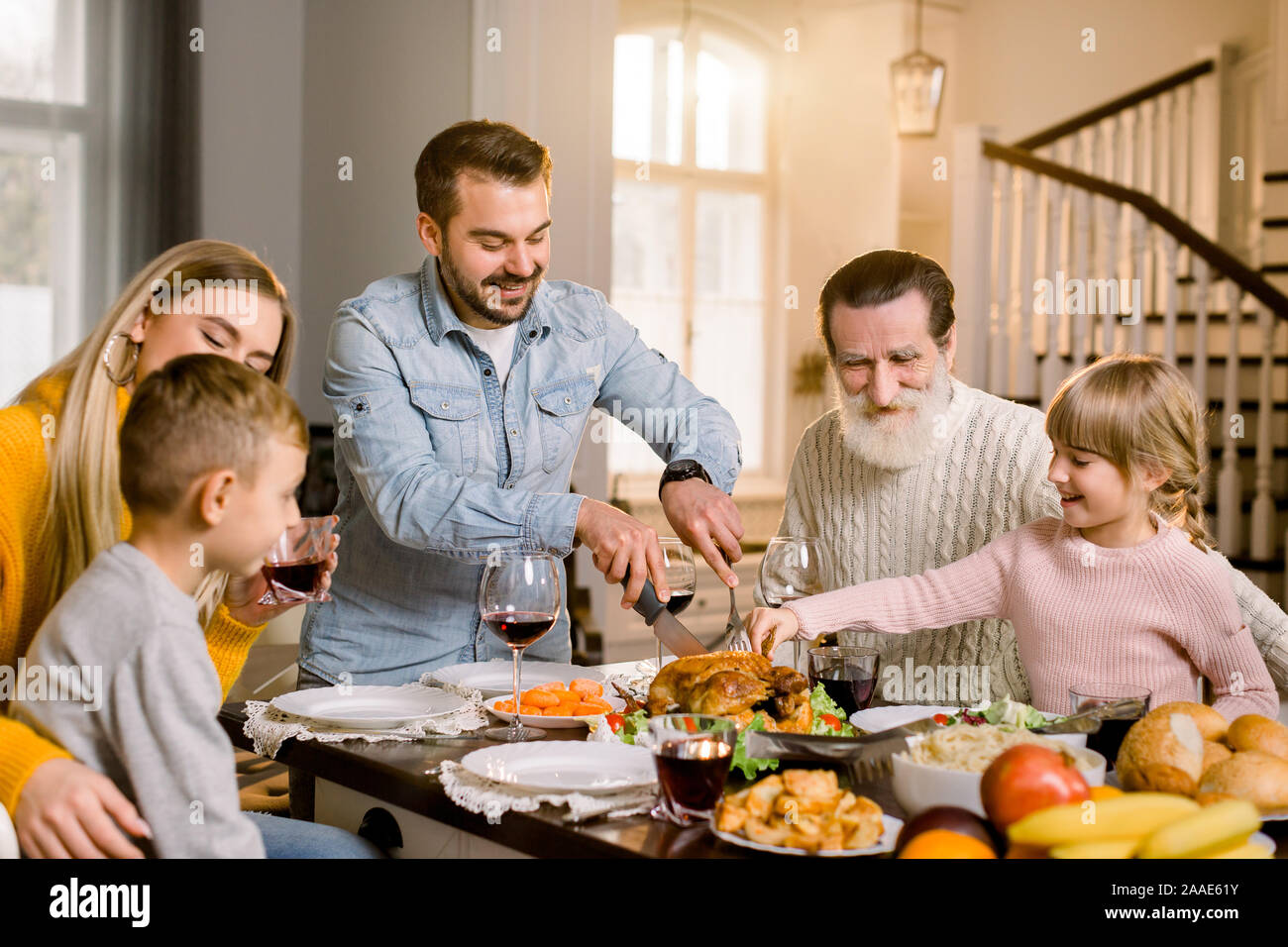 happy excited family celebrating thanksgiving while cutting turkey ...