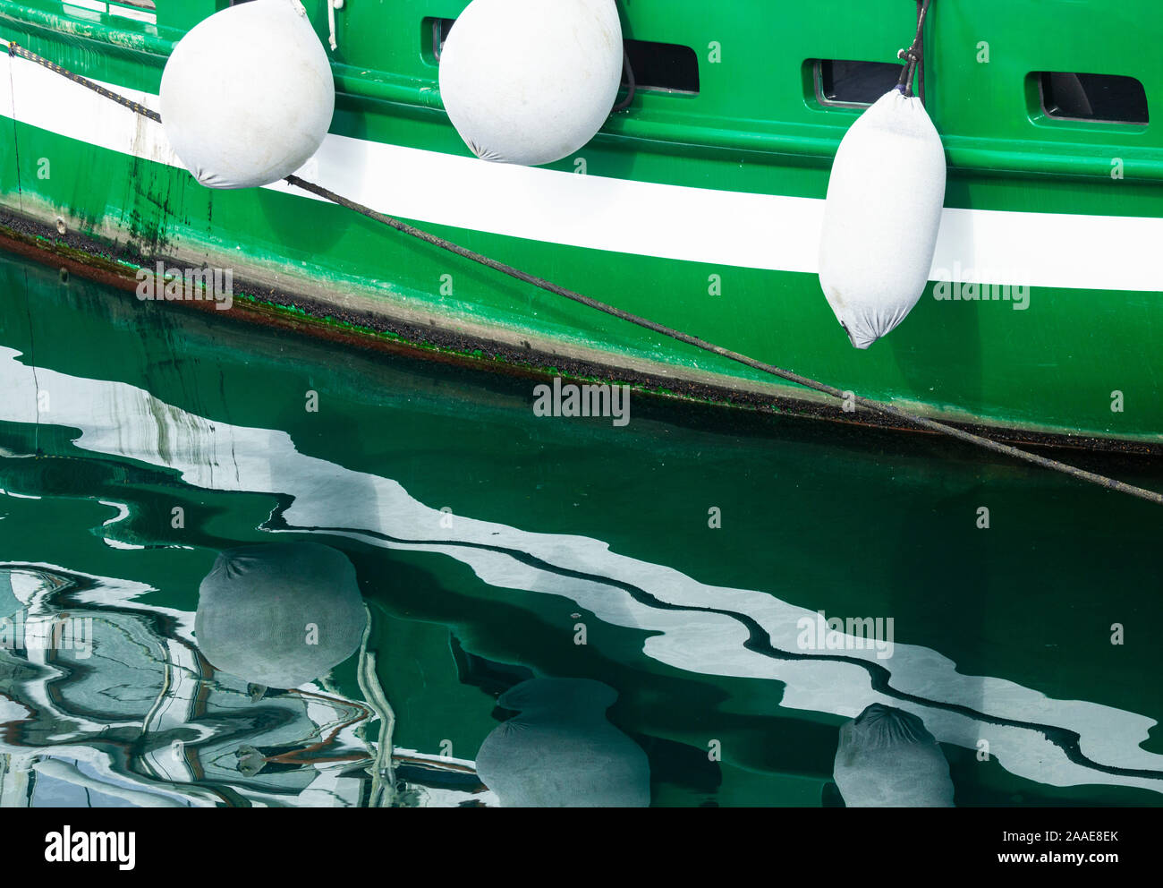 Green boat reflected in water Stock Photo - Alamy